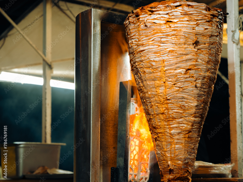Grilling traditional trompo al pastor street taco pork meat on spit ...