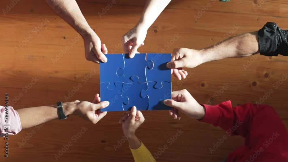 Top down view of skilled business people assemble blue jigsaw puzzle on ...