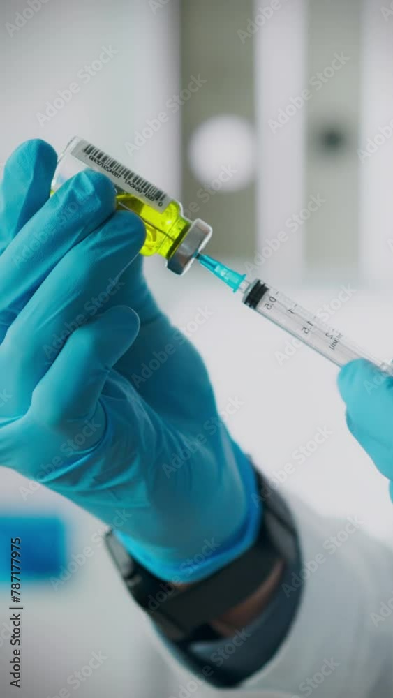 Vertical screen. An anesthesiologist wearing protective gloves prepares ...