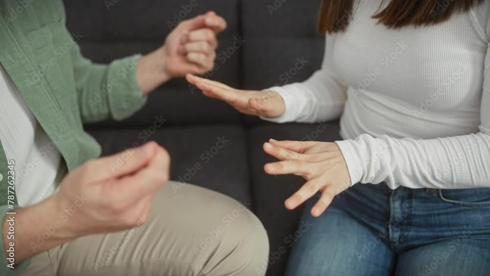A man and woman interact with hand gestures in an indoor living room ...