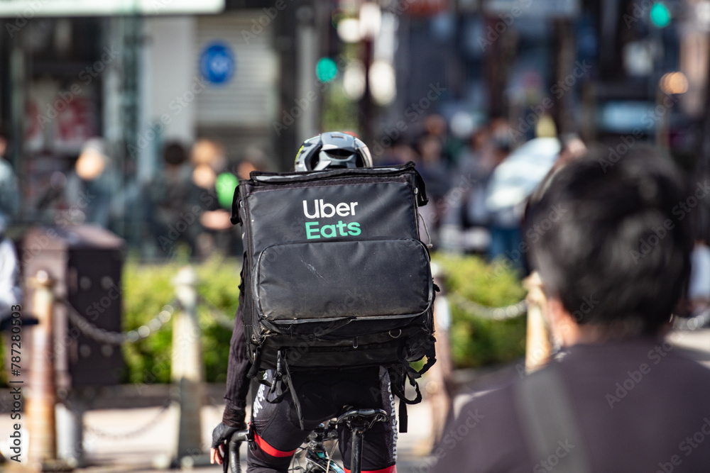 Tokyo, Japan - April 7, 2024 : Uber Eats rider cycling in the street ...