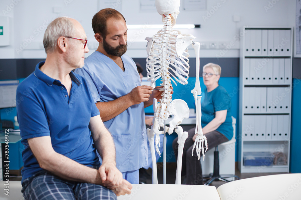 In physiotherapy clinic, orthopedist explains spinal cord on human ...