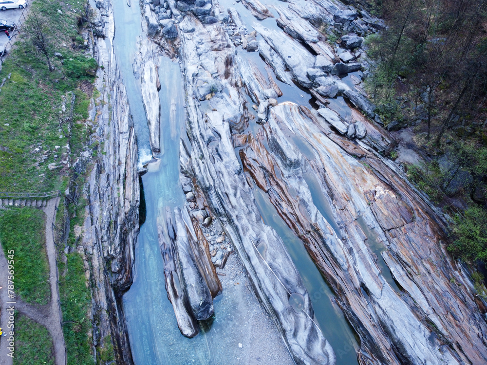 An aerial photo of a dry riverbed with boulders, trees, and a stream ...