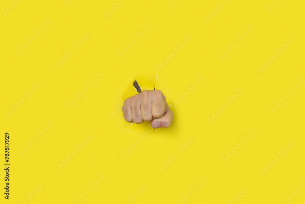 Fist punch through yellow paper background. Concept of aggression ...