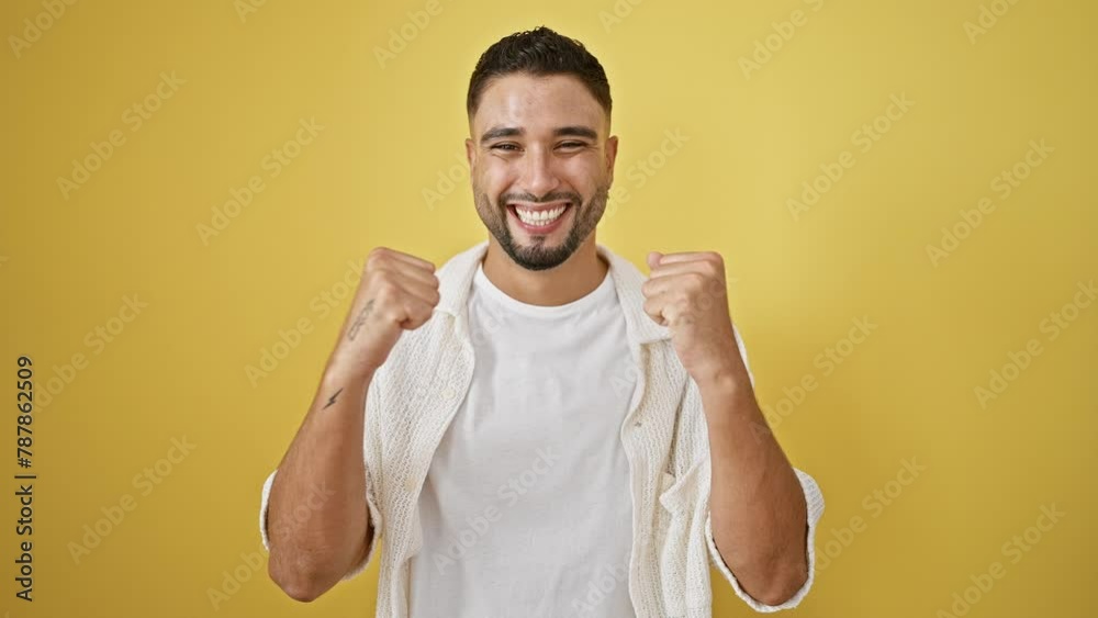 Overjoyed young arab man celebrates victory with arms raised, eyes ...