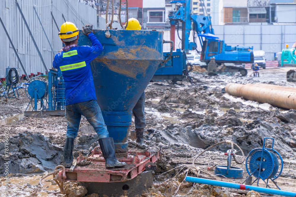 Two Constuction piling worker holding Concrete bucket for pouring ...