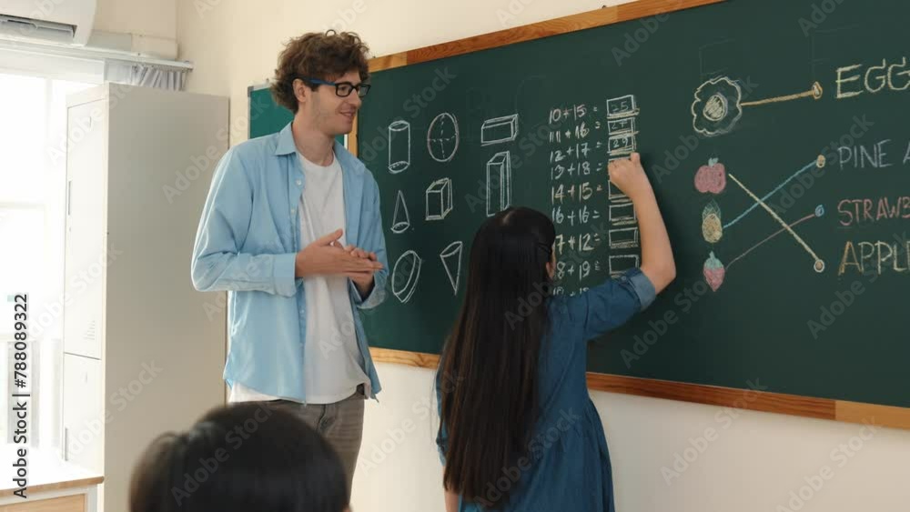 Vidéo Stock Young asian girl writing math formula at blackboard while ...