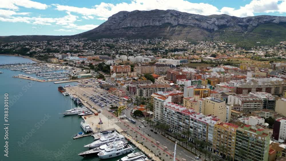 Panoramic aerial view of Denia city and part of the port. Drone panning ...