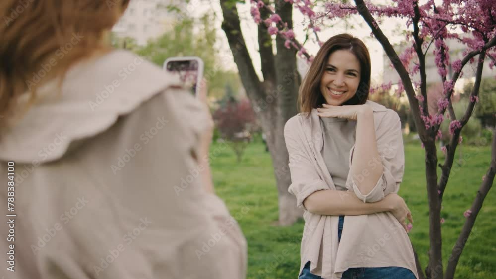 two incredibly beautiful young women filming each other on a smartphone ...