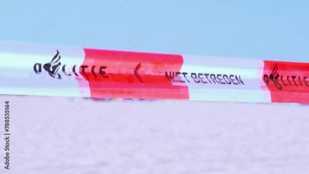 Crime scene on sandy beach marked with red and white police tape ...