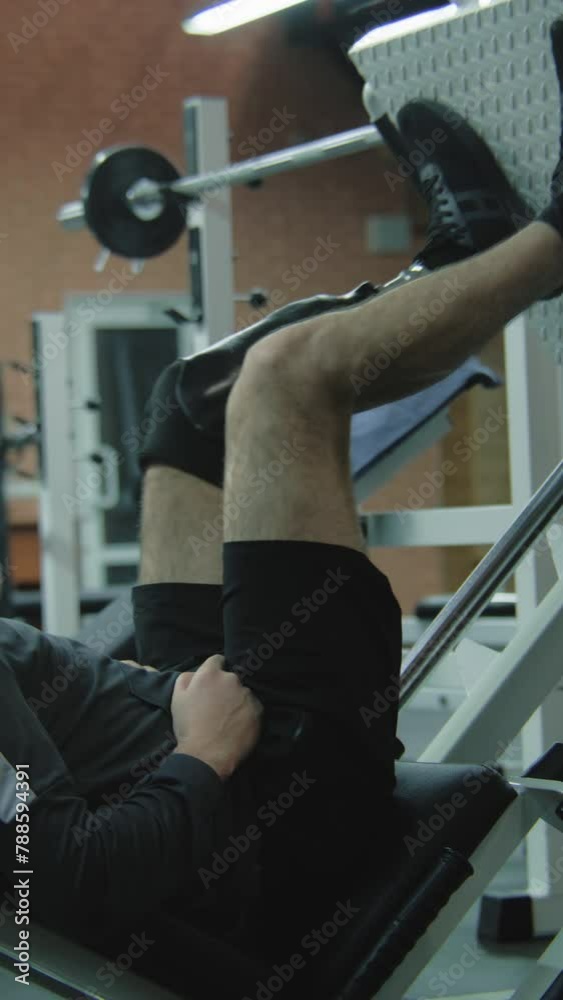 Vertical shot man with prosthetic leg exercises on leg press machine in ...