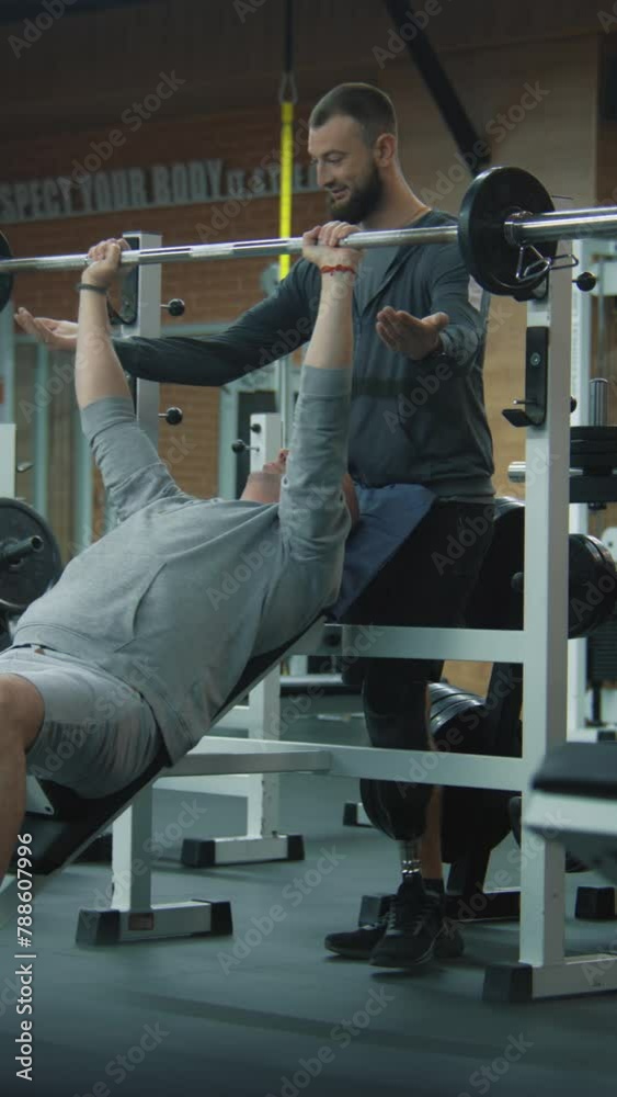 Vertical shot man with prosthetic leg exercises with barbell in modern ...