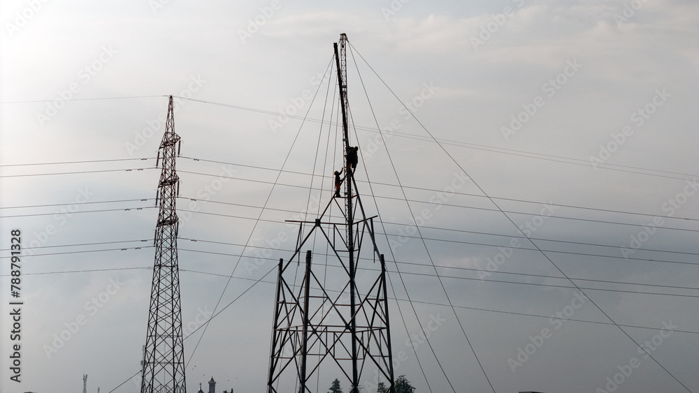 construction of electric pylons. people climbing power towers to erect ...
