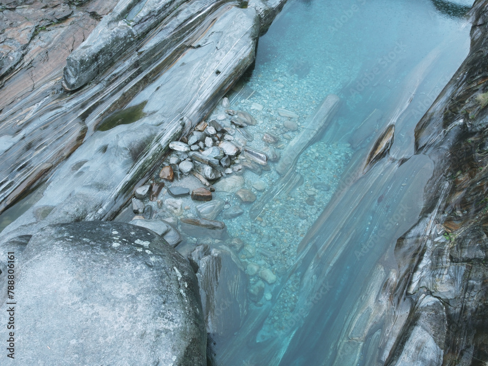 An aerial photo of a dry riverbed with boulders, trees, and a stream ...
