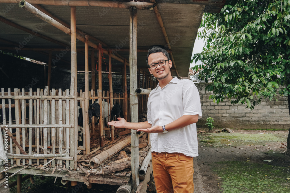Excited young Asian man standing in front of traditional cage made from ...