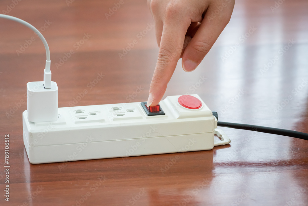 Close-up of electrician's hand using red push button to turn on the ...