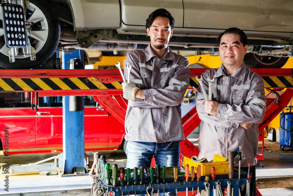 Diversity mechanic teamwork, a Thai and Japanese man in blue uniforms ...