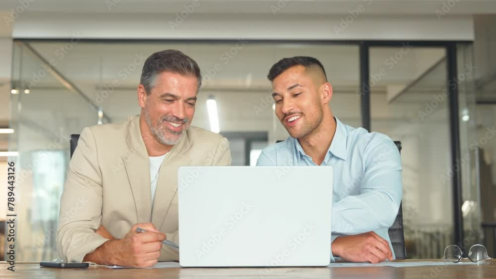 Two busy happy business men partners working together talking using ...