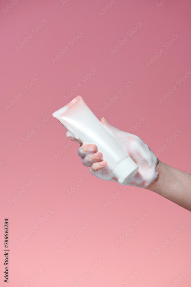 Woman with cleansing foam on hand holding tube of cosmetic Stock Photo ...
