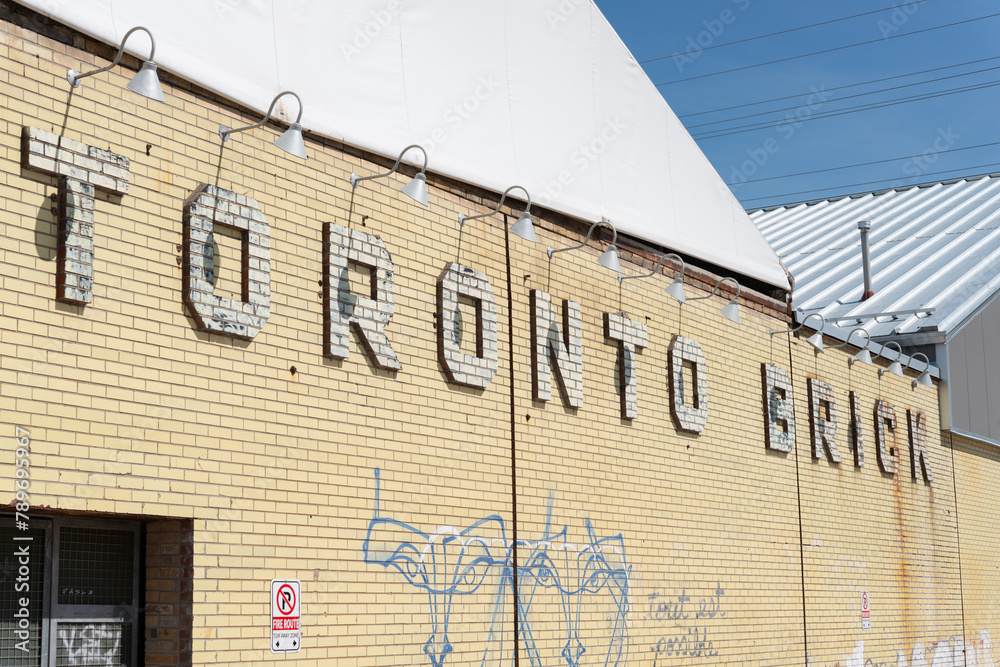 Toronto Brick white brick relief sign on a yellow brick wall located at ...
