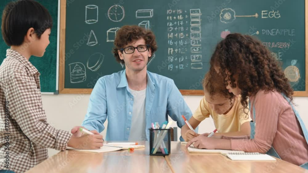Vidéo Stock Smart teacher explain idea while diverse children drawing ...