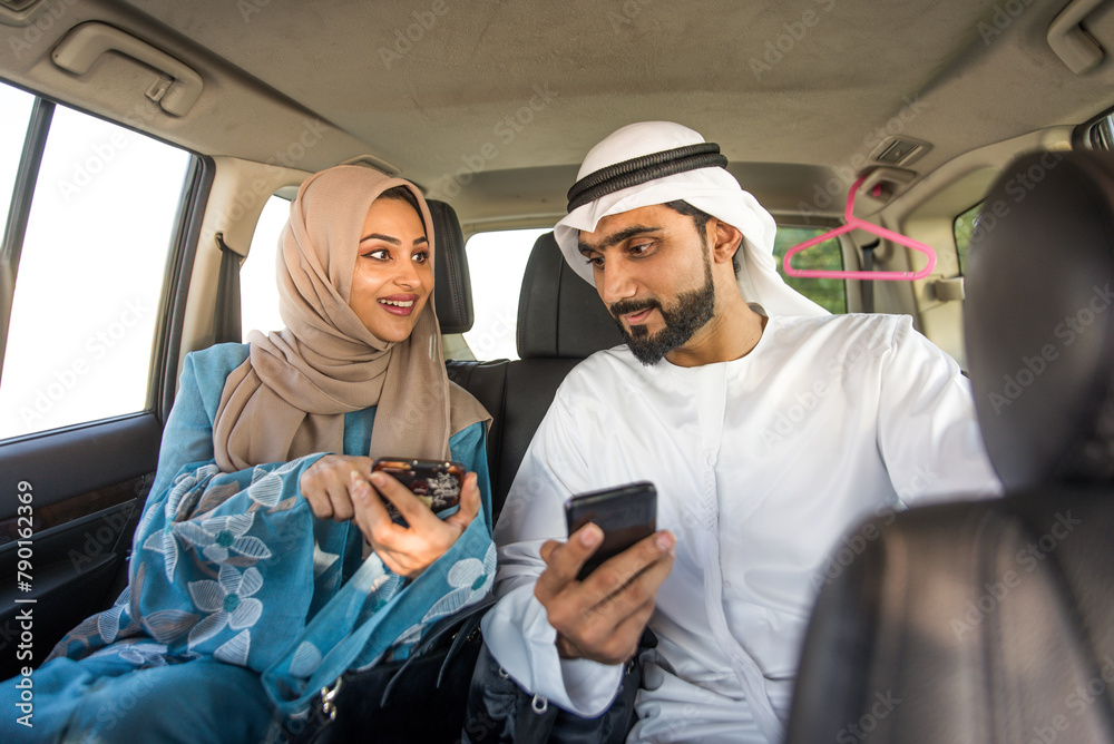 Arabic couple wearing emirati clothing driving in a car Stock Photo ...