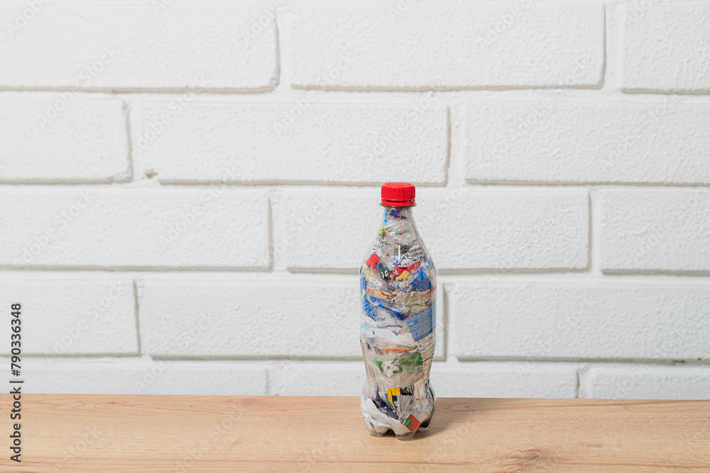 one eco brick PET bottle stuffed with plastic waste with white brick ...