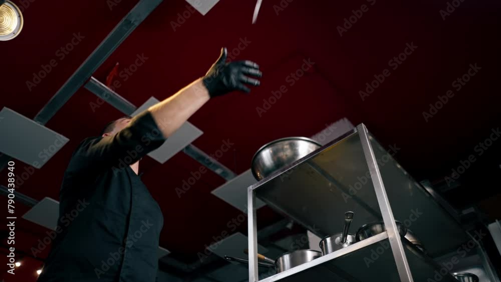 a chef in the kitchen in a black jacket demonstrates the skills of ...