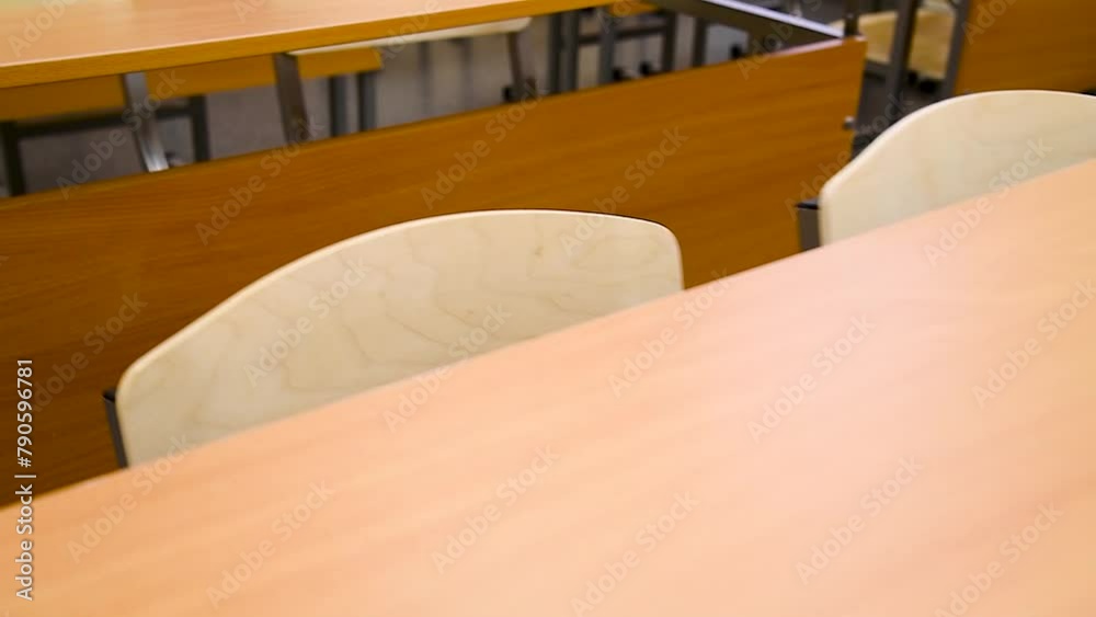 An empty school classroom. School desks in a row facing the blackboard ...