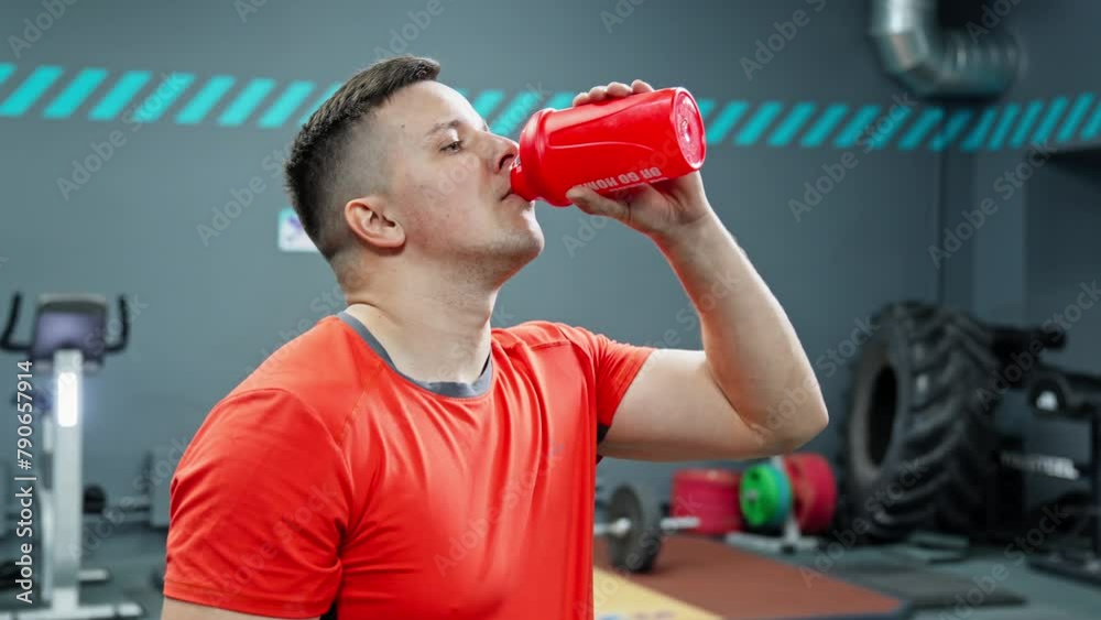Sportsman drinking protein shake in gym. Athlete drinking water during ...