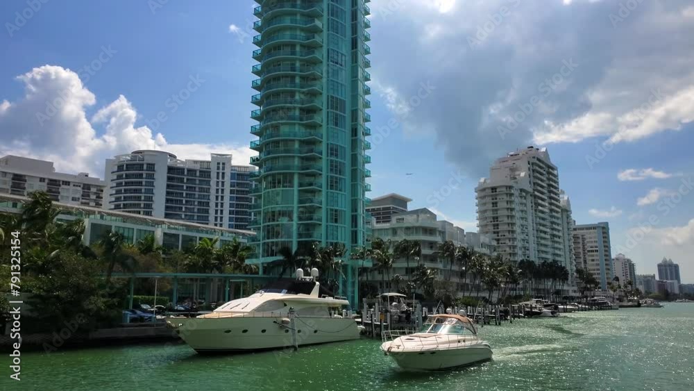 Moving shot going through the waterways of Miami with nice homes and ...