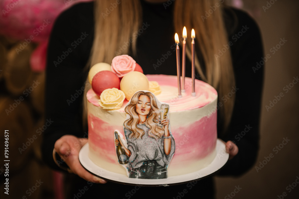 Birthday cake in female hands. Cake with candles, topper of a girl with ...