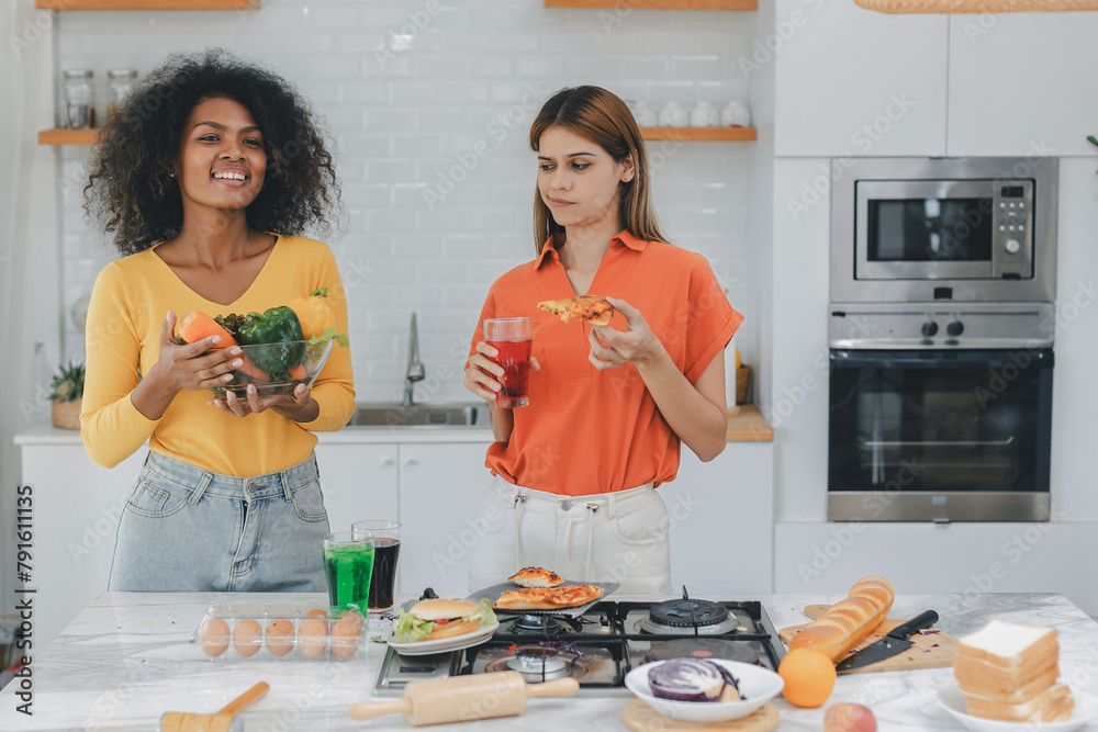 Two women choosing between vegetable and sausage, organic food vs gmo ...