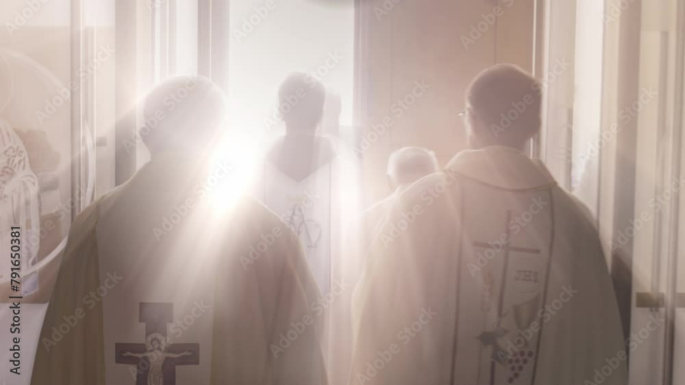 Priests walking from church door into bright light back view tracking ...
