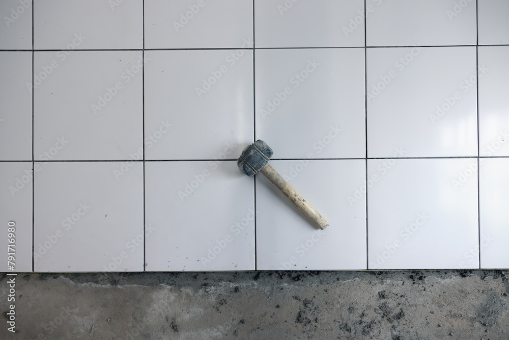 Tile floor under construction at interior. Include mallet tool ...