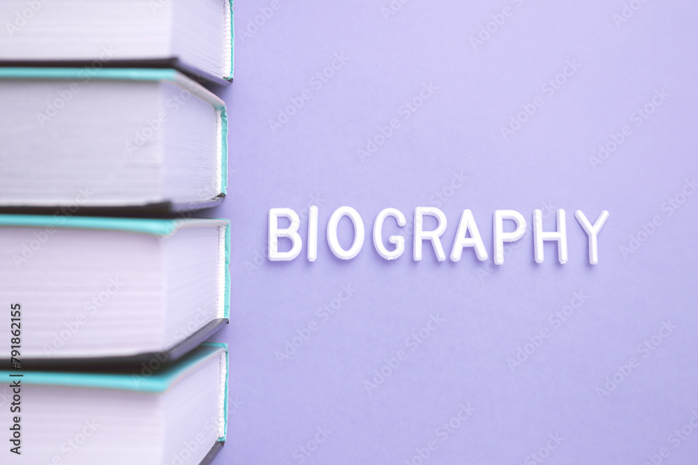 A stack of books with biography written on the cover in electric blue ...