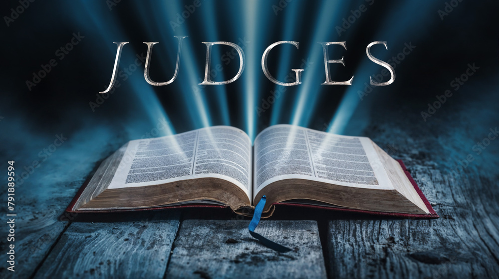 The book of Judges. Open bible with blue glowing rays of light. On a ...