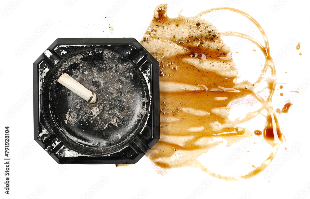 Cigarette butt in black ashtray and spilled coffee espresso with foam ...