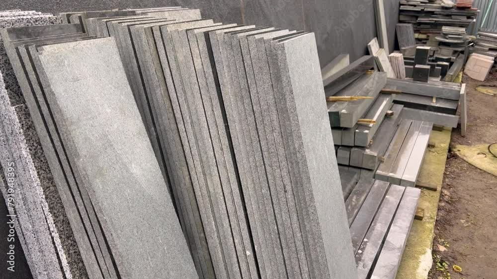 Granite slabs stand in rows. Granite slabs for tombstones. Workshop for ...