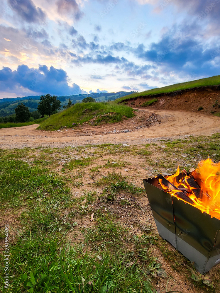 Idyllic campfire in a fire basket, campfire burning on an off-road ...