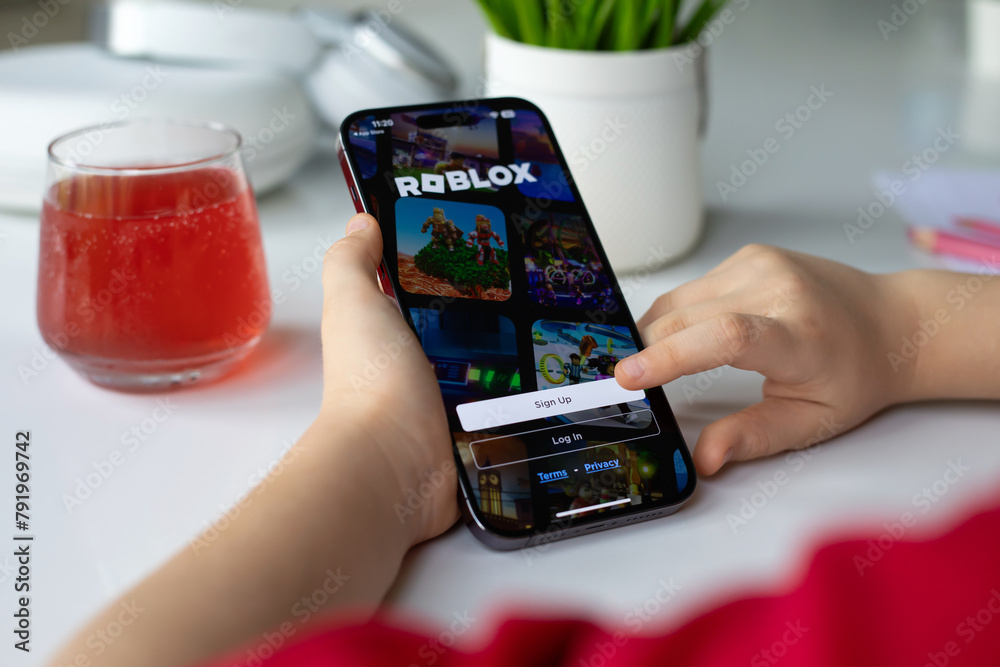Children hands holding iPhone 15 Pro Max with game Roblox Stock Photo ...
