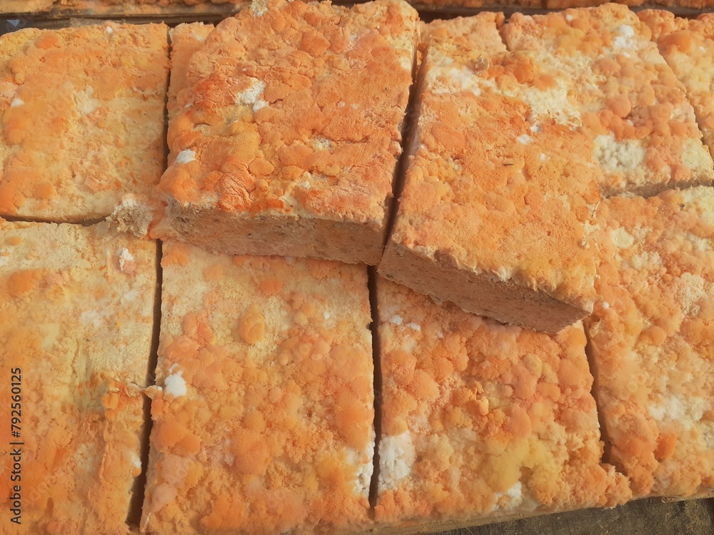 Raw oncom on a wooden shelf at a traditional roadside market trader ...