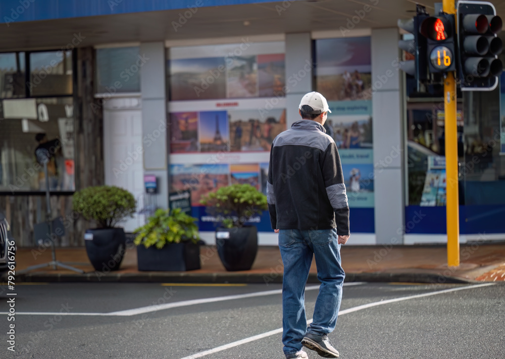Man walking across the road with pedestrian traffic signal on. Tourism ...