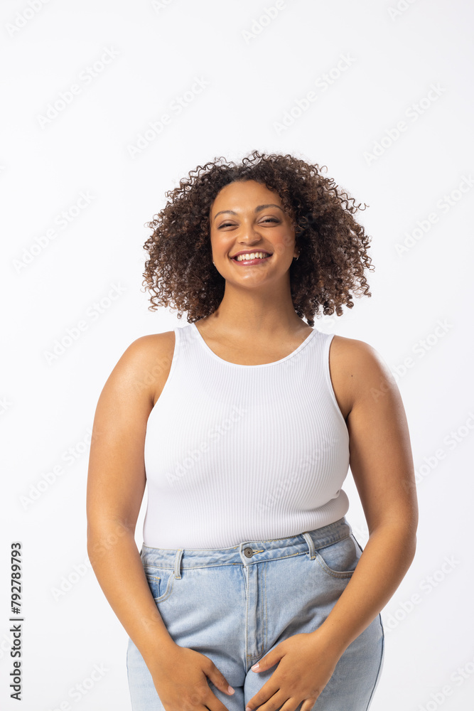 Biracial young female plus size model stands with hands on hips, white ...