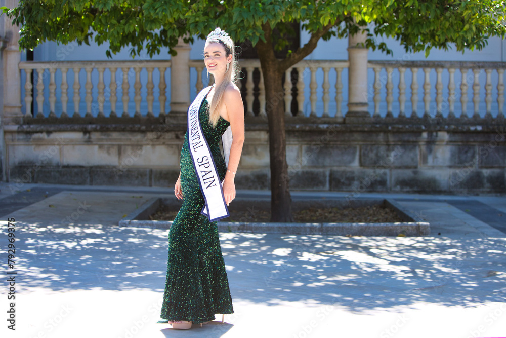 Pretty young woman winner of a beauty pageant dressed in a green ...