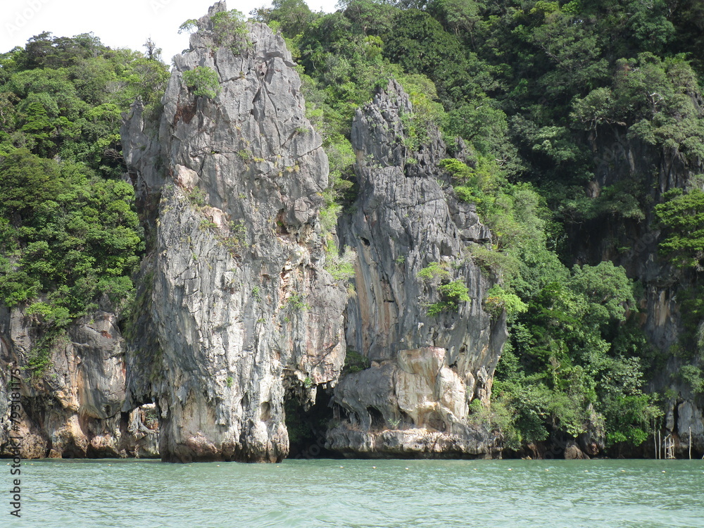 twin rock formations tower above the sea framing an entrance to a ...