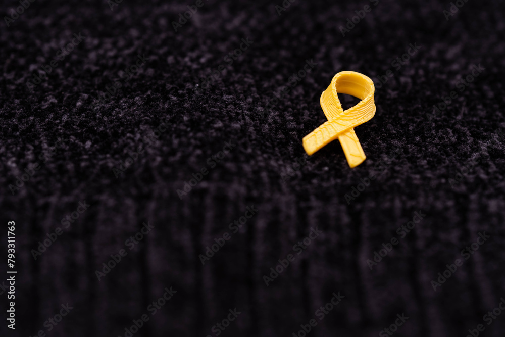 Hands placing a yellow ribbon pin on fabric, the international symbol ...