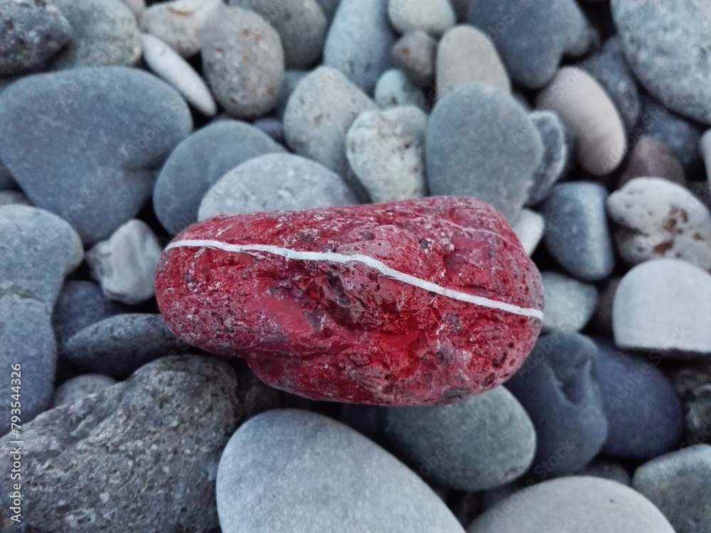 Red pebble stone rock & white line on sea beach background. Gray pebble ...