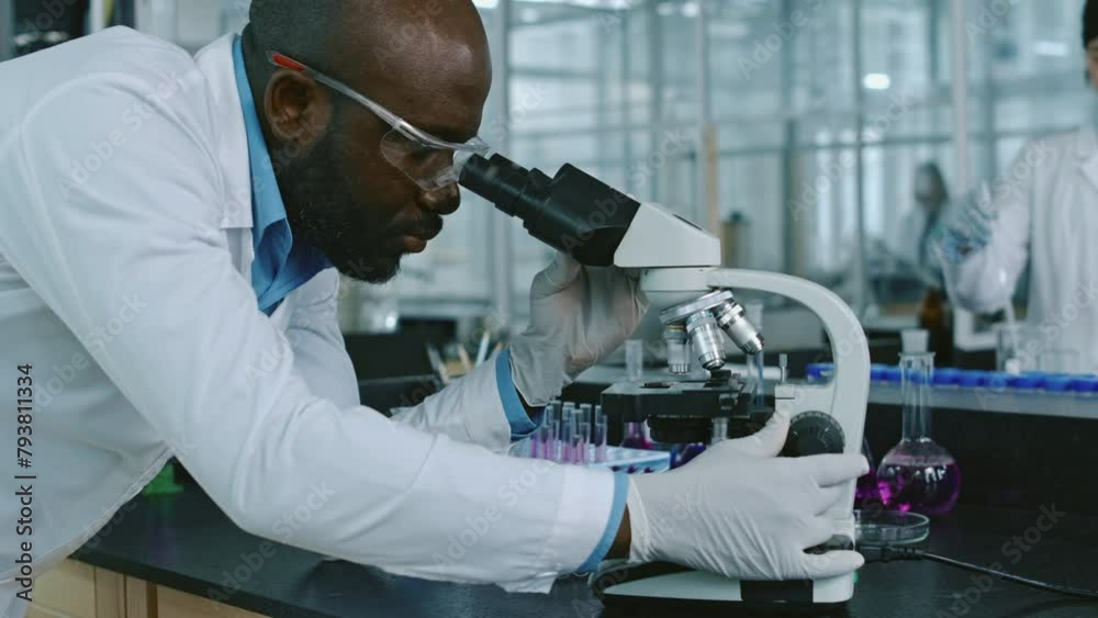 Medium side shot of African American male researcher in white lab coat ...