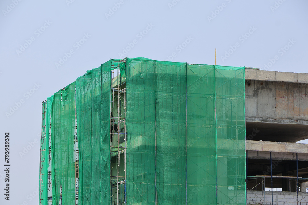 High-rise buildings under construction have coverings to prevent debris ...